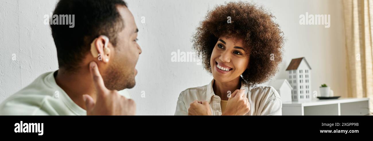 A smiling African American couple uses sign language to communicate at ...