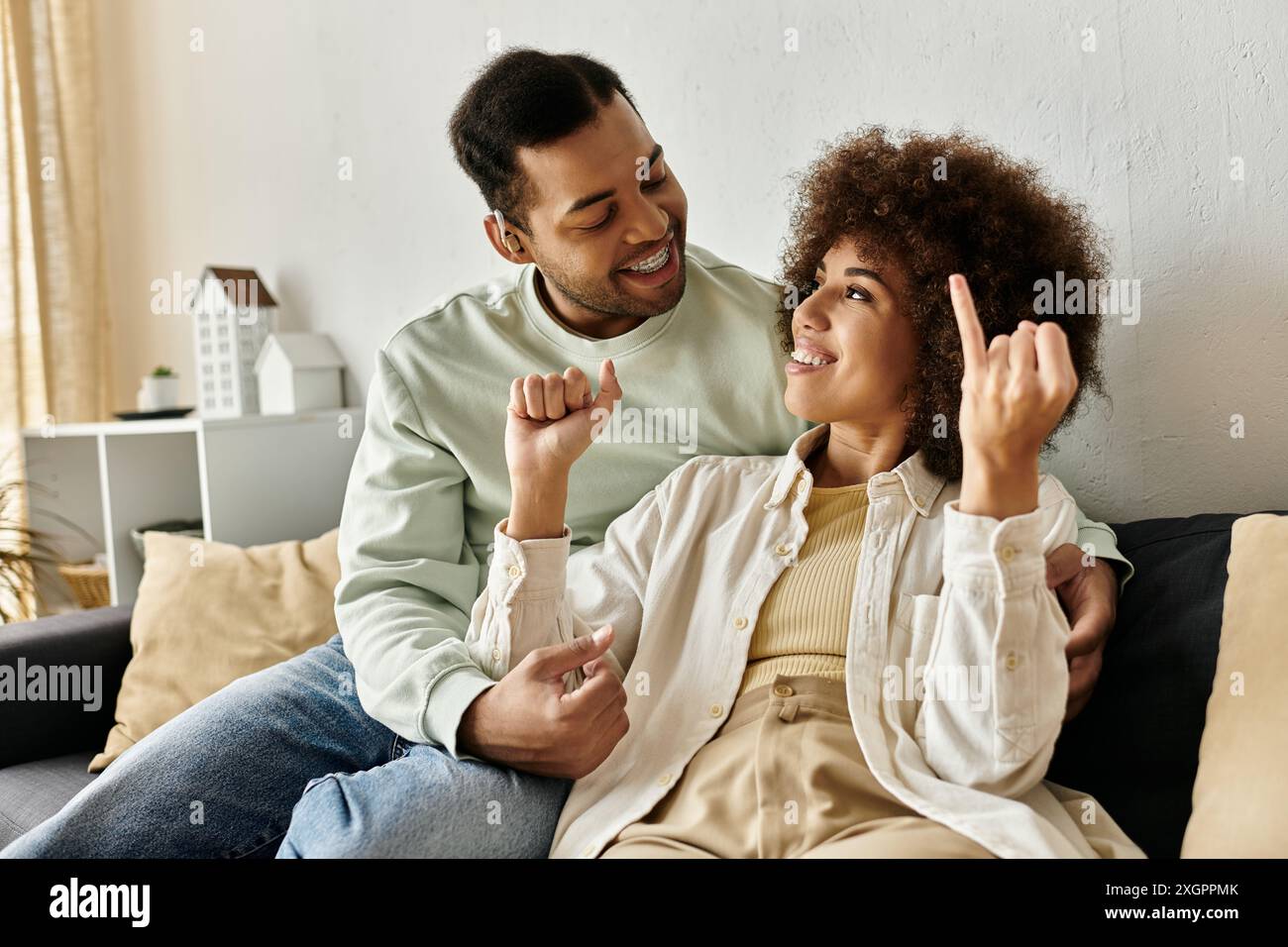 A happy African American couple communicates using sign language while ...