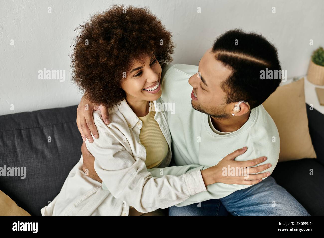 A couple communicates through sign language on a couch at home Stock ...