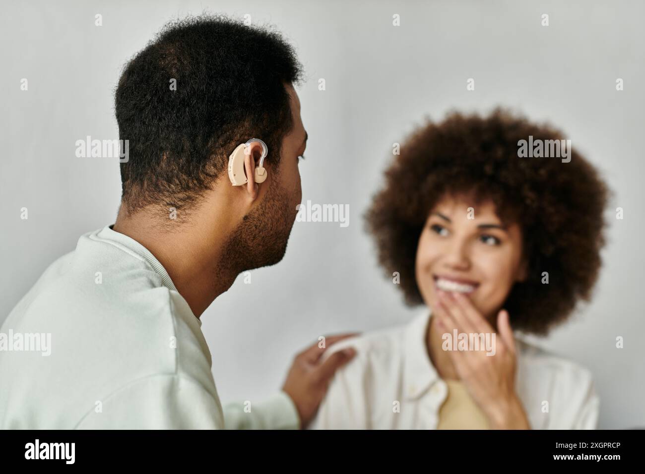 A couple at home, communicating with sign language, with the man ...