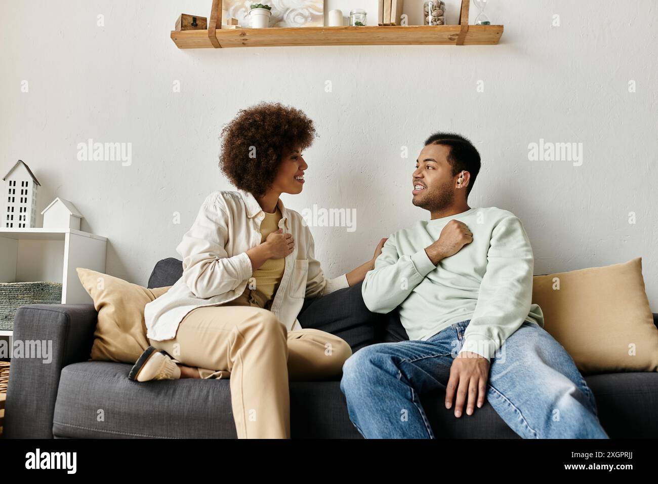 A couple sits on a couch and converses using sign language Stock Photo ...