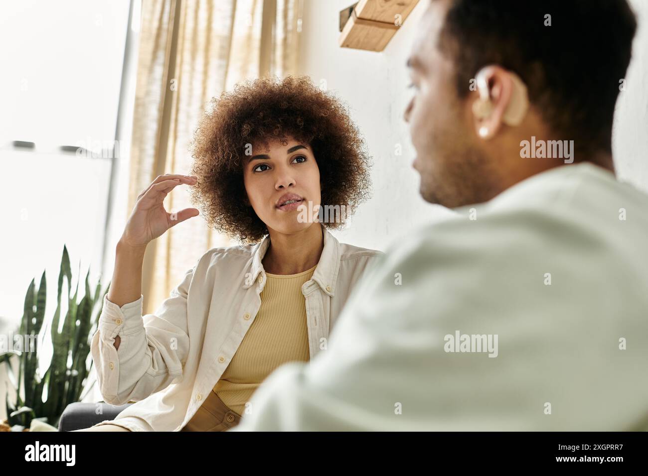 An African American couple using sign language to communicate in their ...
