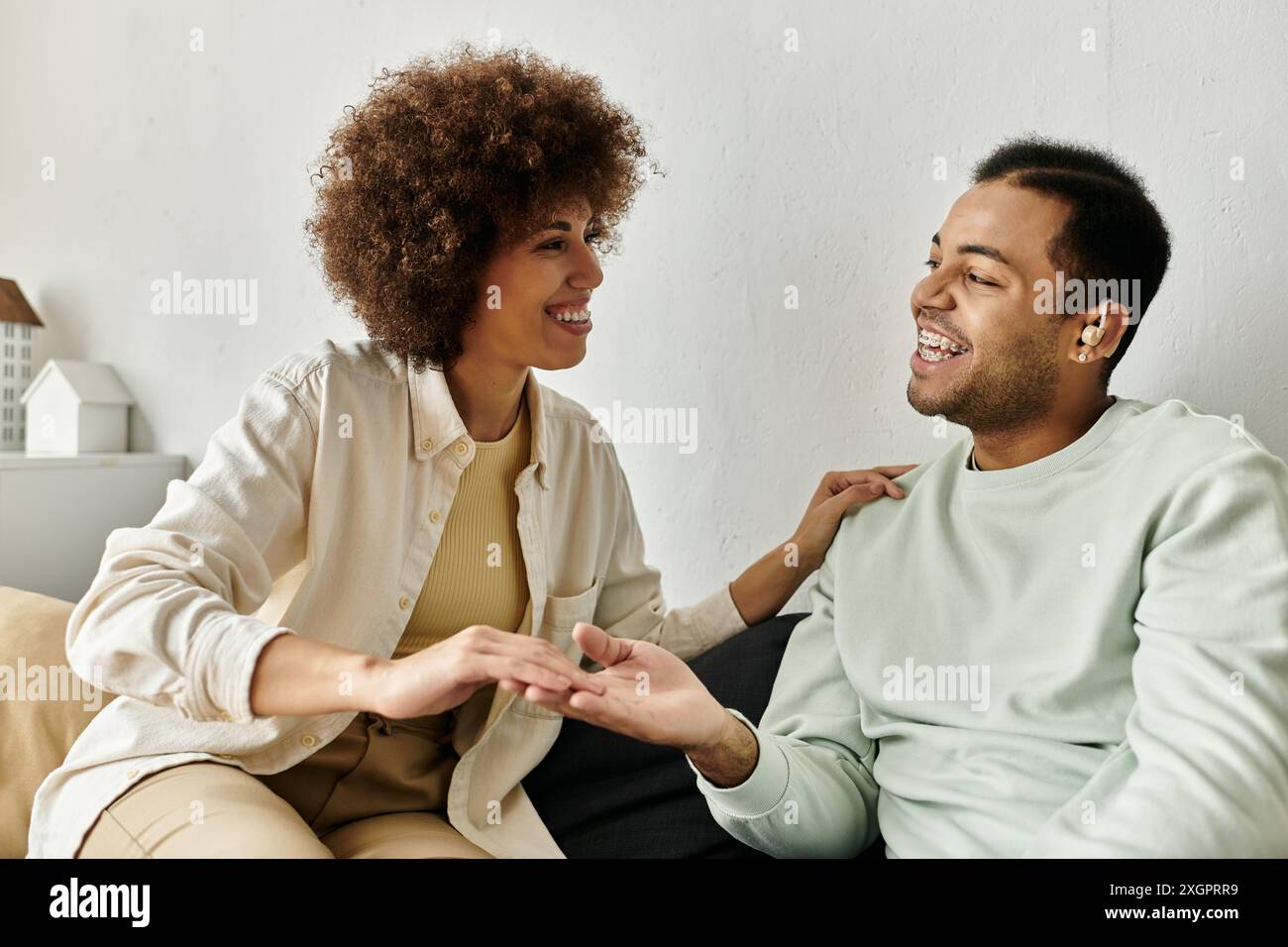 An African American couple communicates in sign language while sitting ...