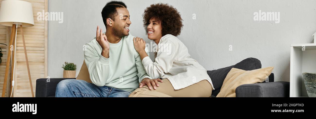A young African American couple uses sign language to communicate while ...