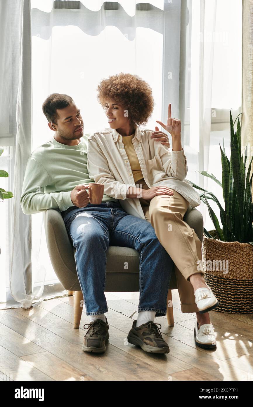 An African American couple sits in a living room, using sign language ...