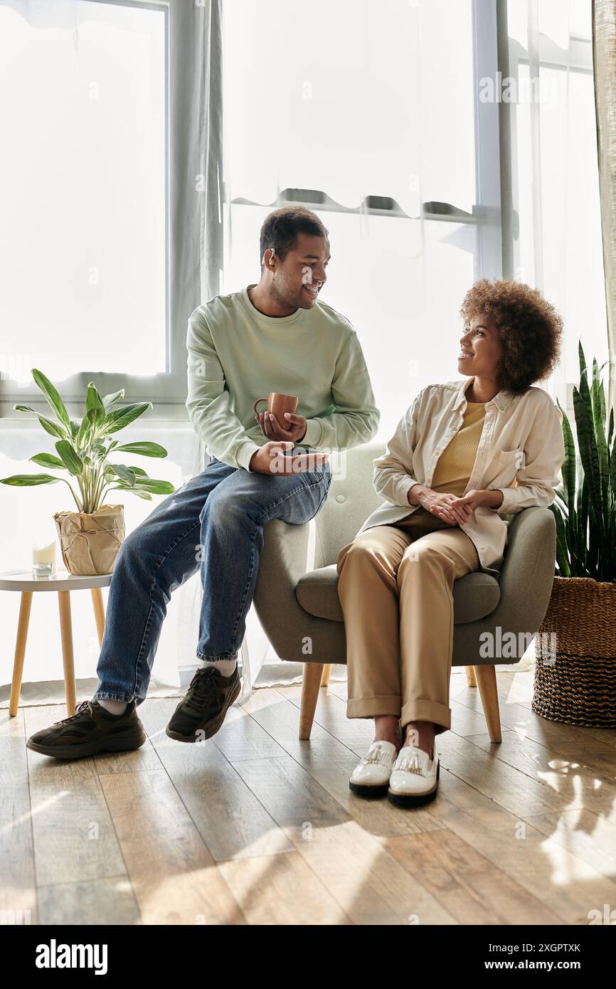 An African American couple sits in their living room, using sign ...