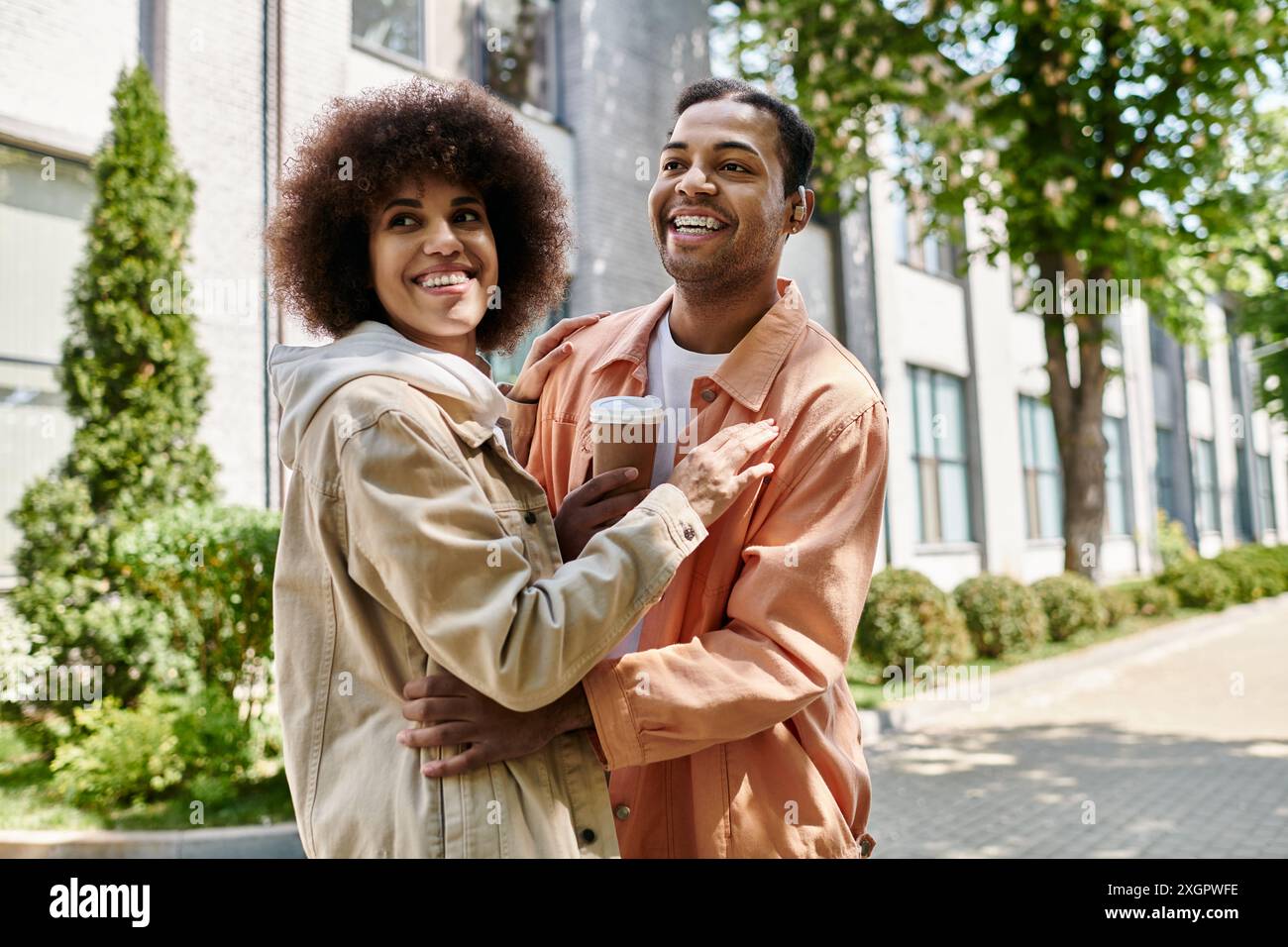 A happy African American couple embraces while walking through a city ...