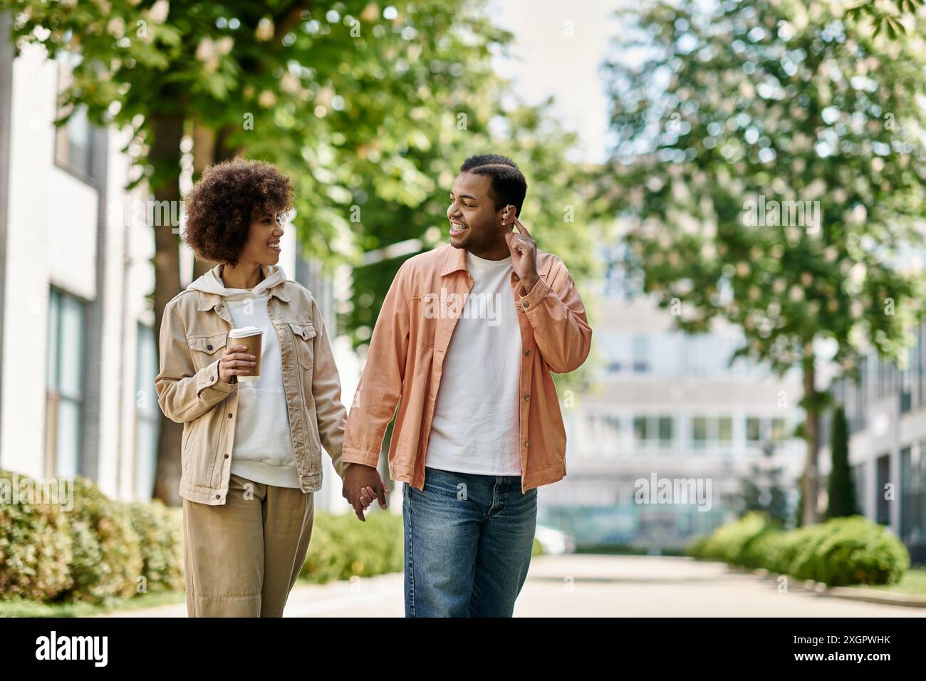 A happy African American couple walks hand-in-hand, using sign language ...