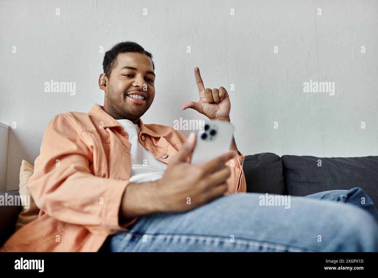 A man communicates using sign language while sitting on a couch Stock ...