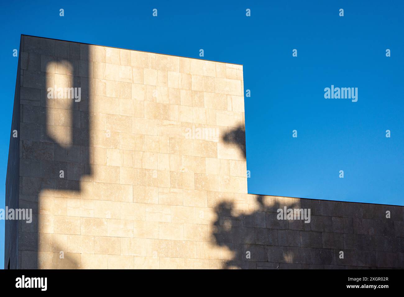 Minimalist modern building facade with distinct shadows cast against a ...