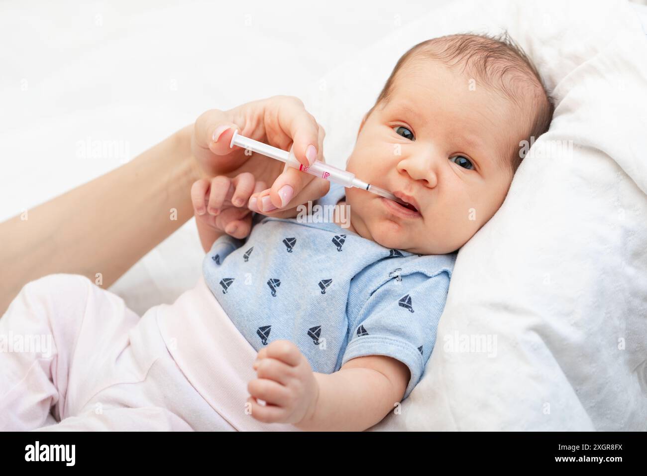 Mother feeding newborn baby with Vitamin K to prevent Vitamin K ...