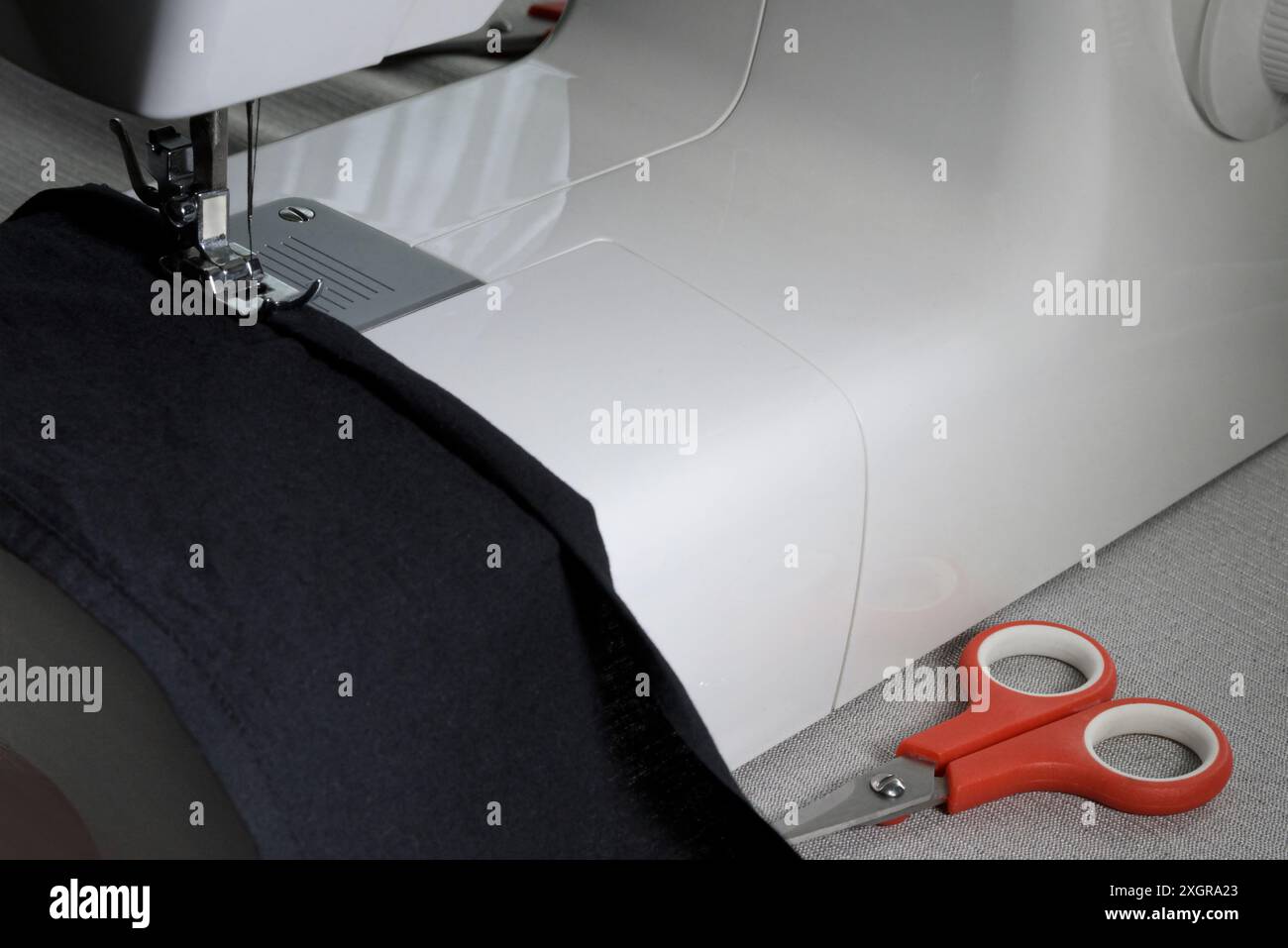 Home sewing machine close-up of the mechanism, a piece of black cloth ...