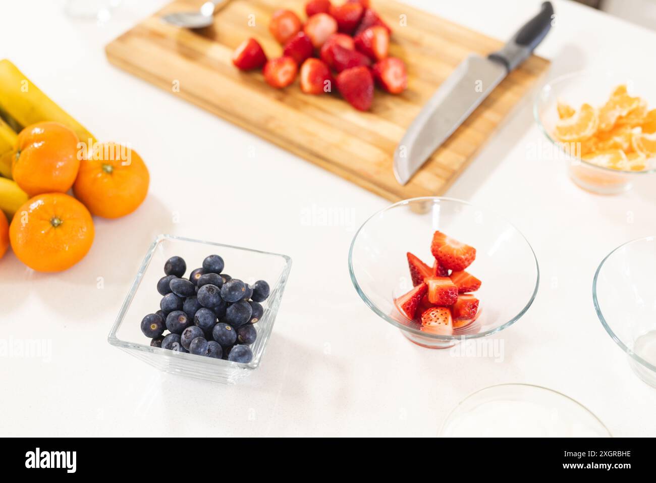 Fruit and knife on chopping board on kitchen worktop for preparation of ...