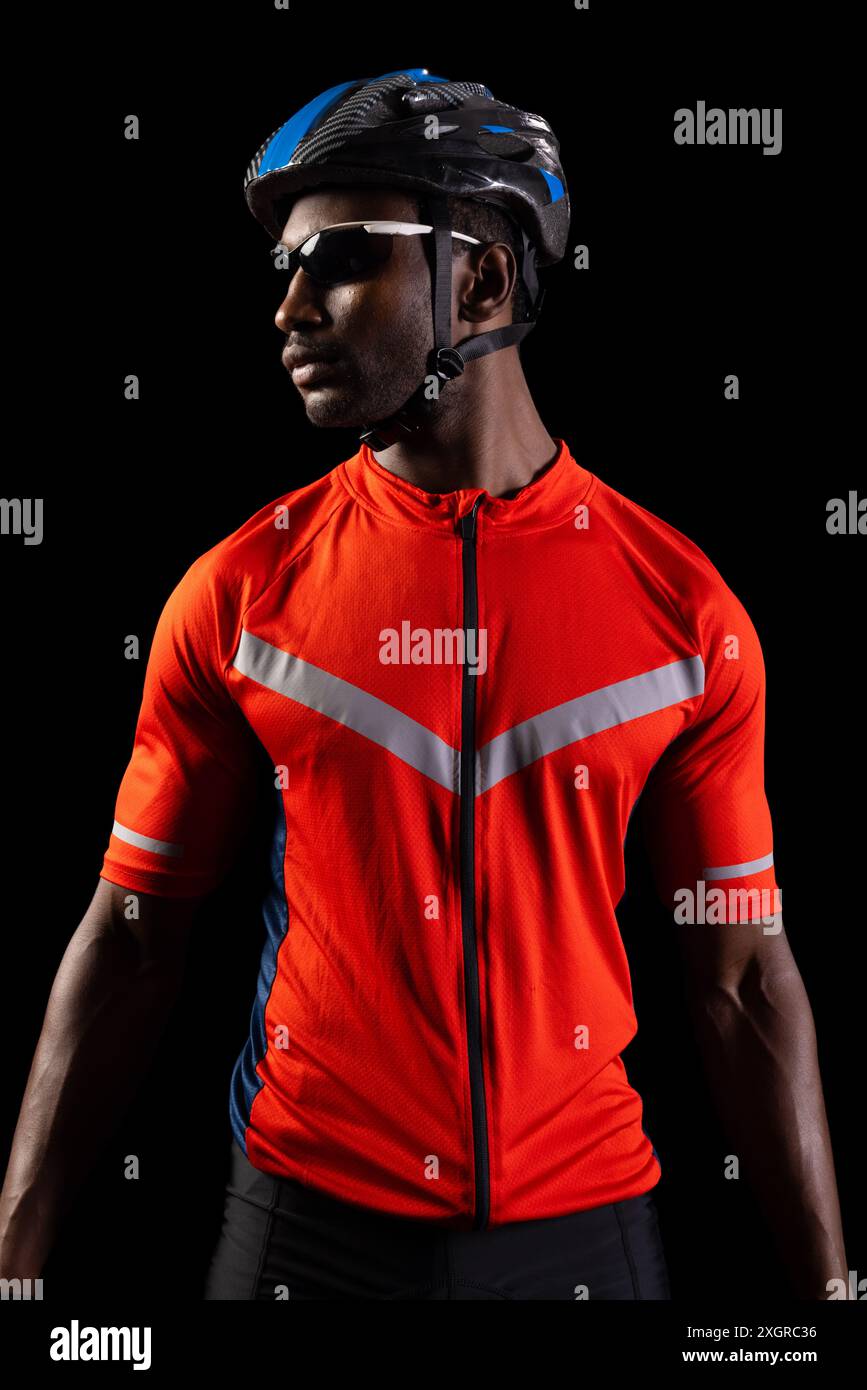 African American cyclist poses confidently on a black background, with ...