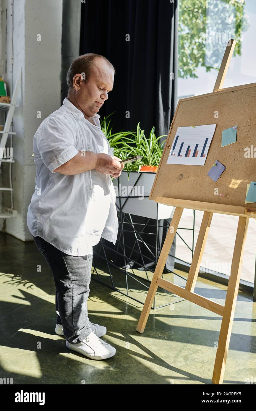 A man with inclusivity reviews a chart on an board in a modern office ...