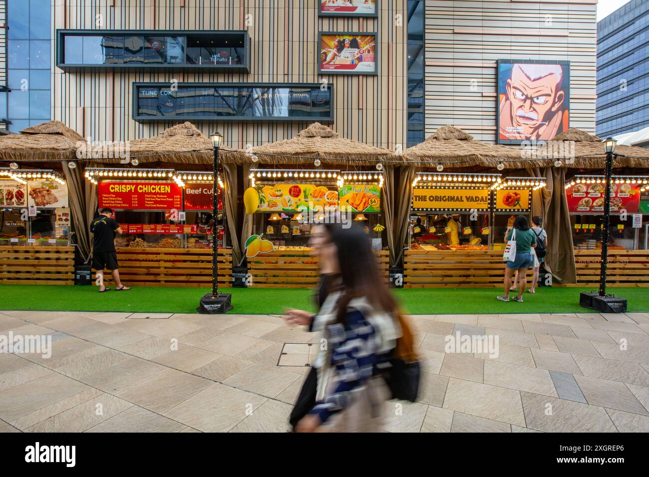 People in blur motion walking pass outdoor street food amenity in ...