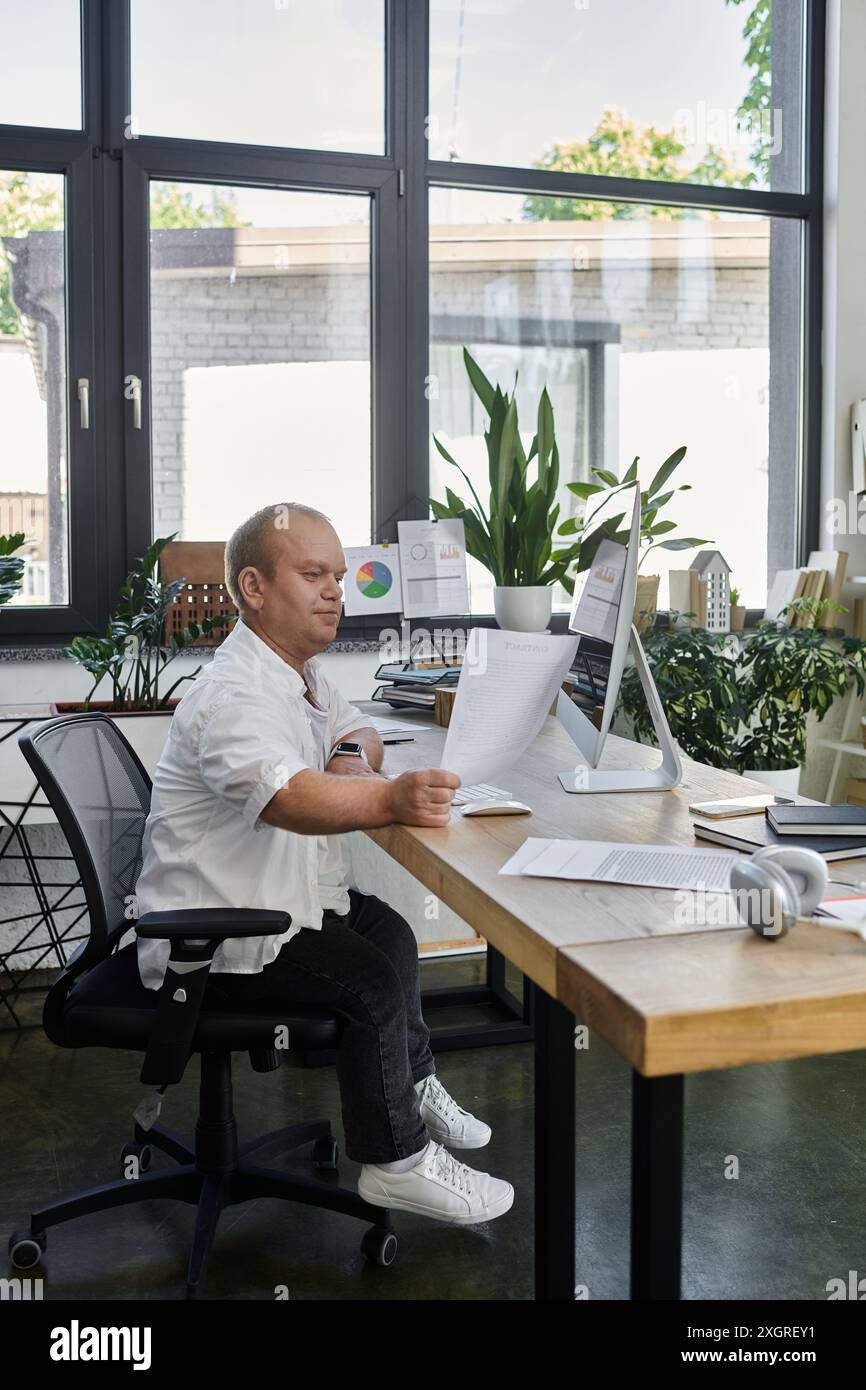 A man with inclusivity works at a desk in a modern office Stock Photo ...