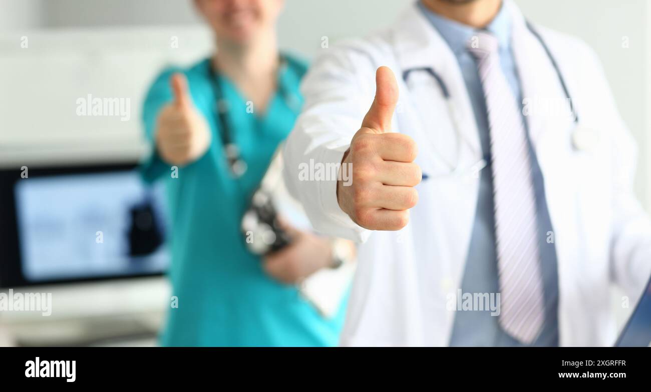 Two doctors show thumb up gesture with hands Stock Photo - Alamy