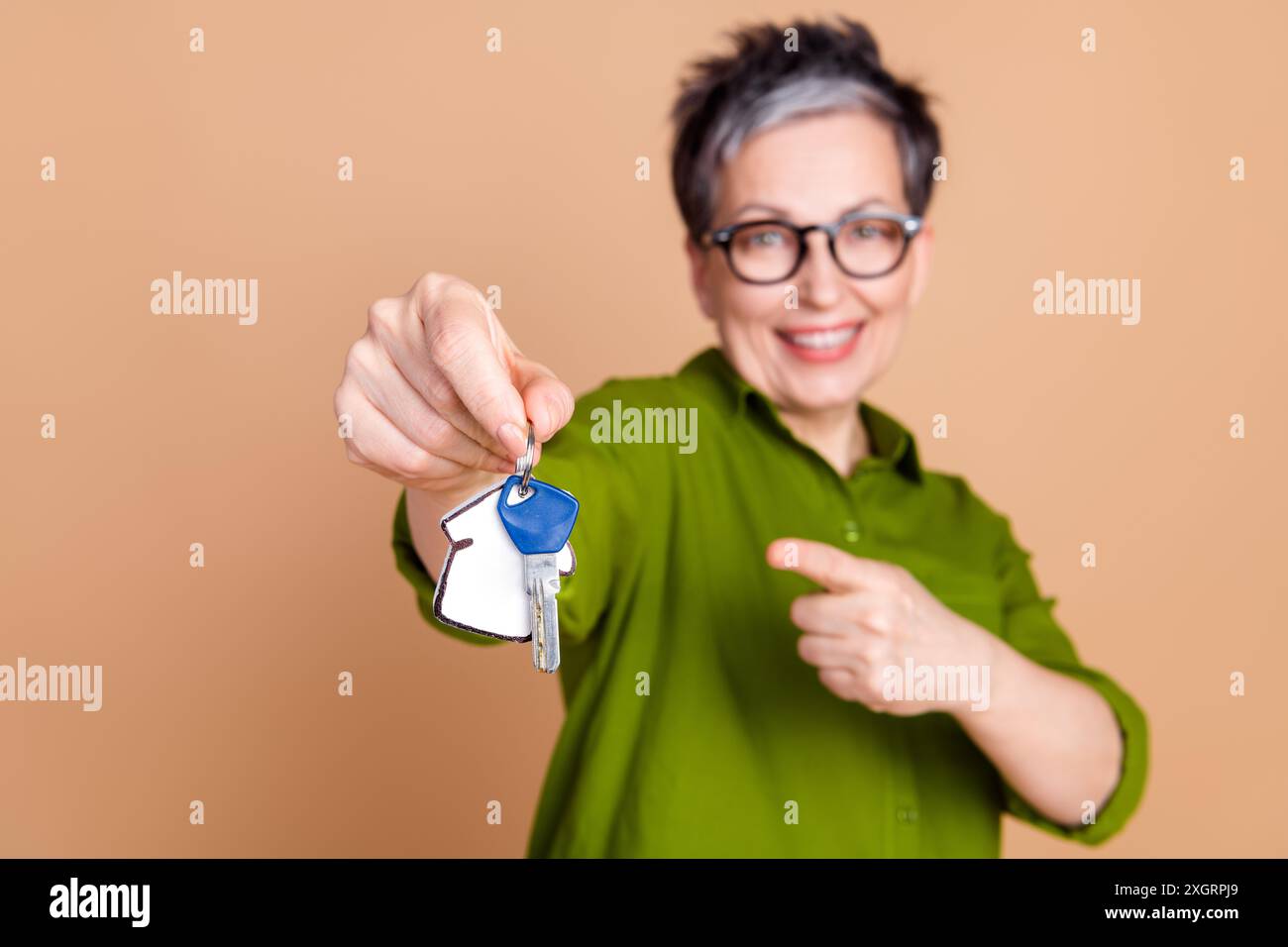 Photo portrait of pretty senior female hold point house keys wear ...