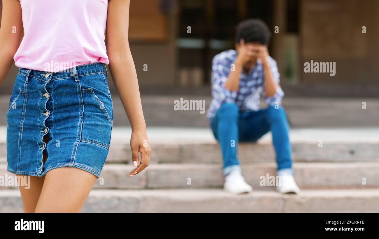 Girl Walking Away From Guy Sitting On Steps Stock Photo - Alamy