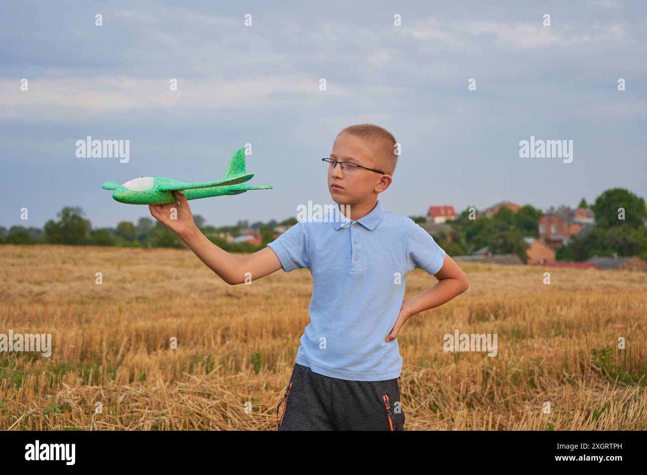 a boy plays with an airplane in a field, a boy with a toy airplane ...