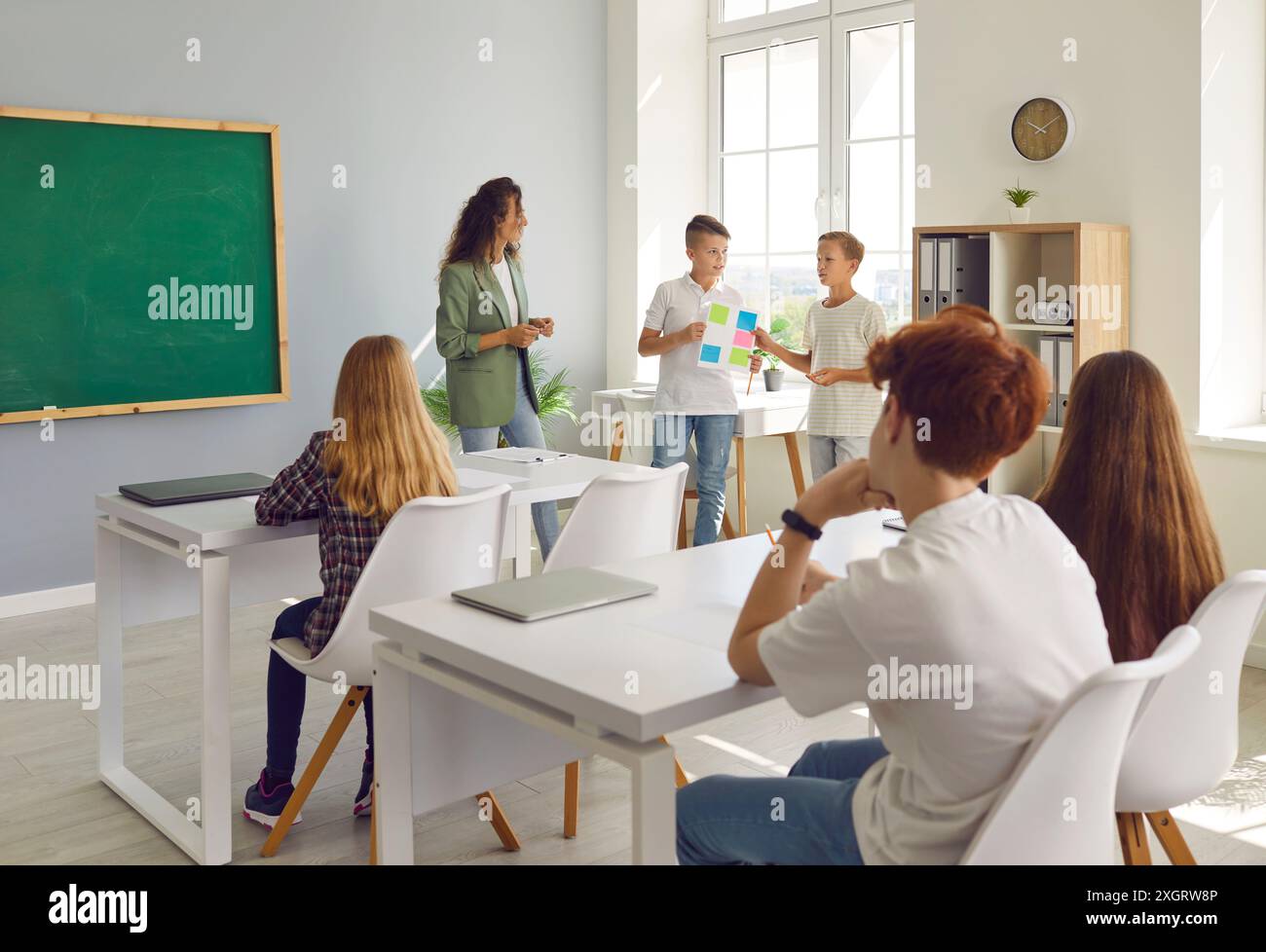 Teacher Guides Students in Classroom Presentation Stock Photo - Alamy