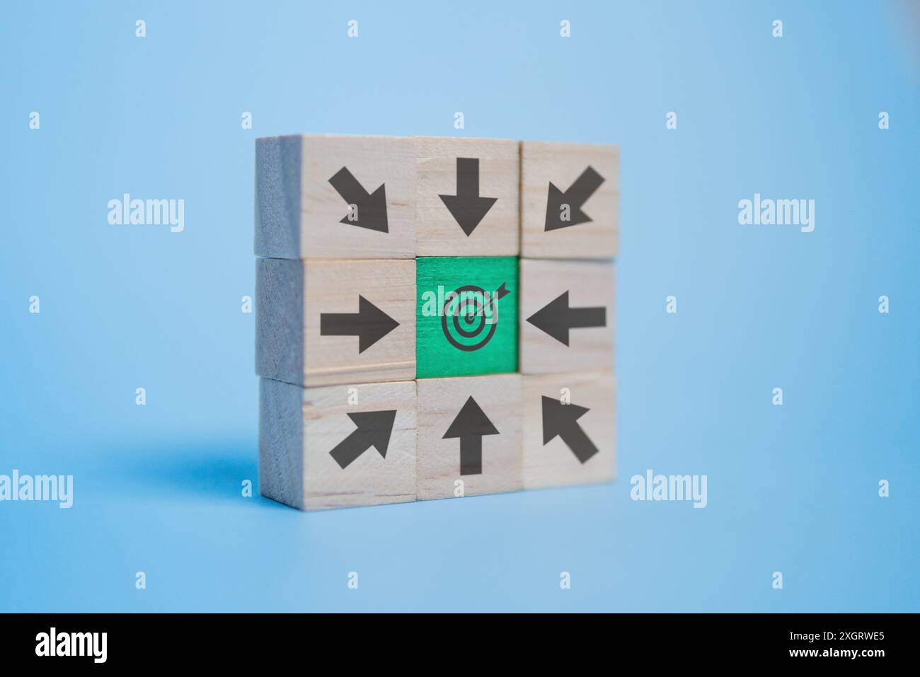 A stack of wooden blocks with various arrows pointing towards a target ...