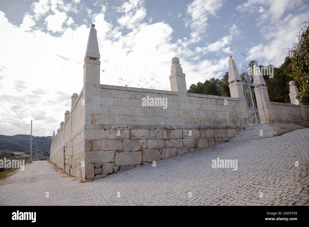 Stone walls and pillars of a historic cemetery with an iron gate ...