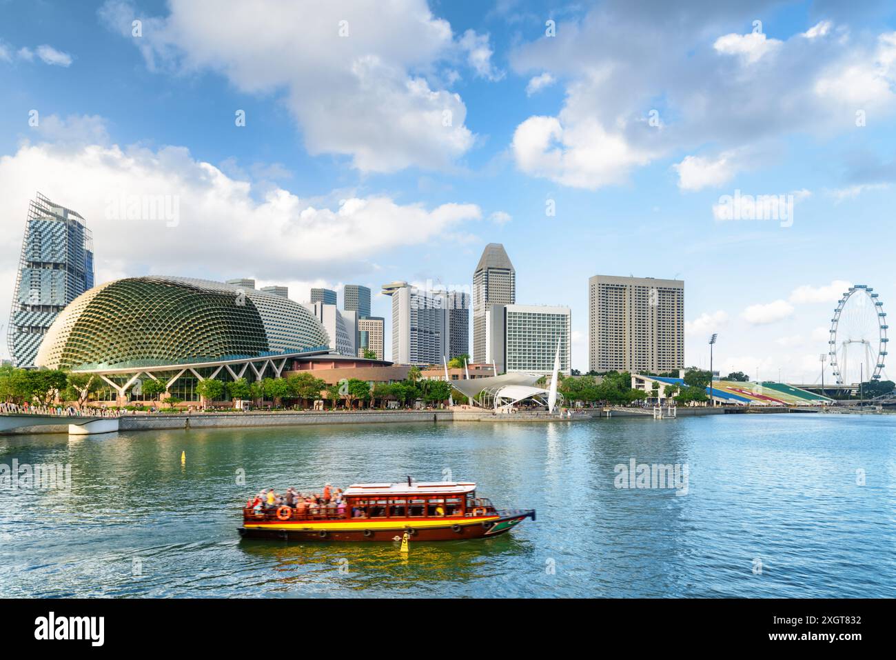 Beautiful view of traditional tourist boat sailing along Marina Bay ...
