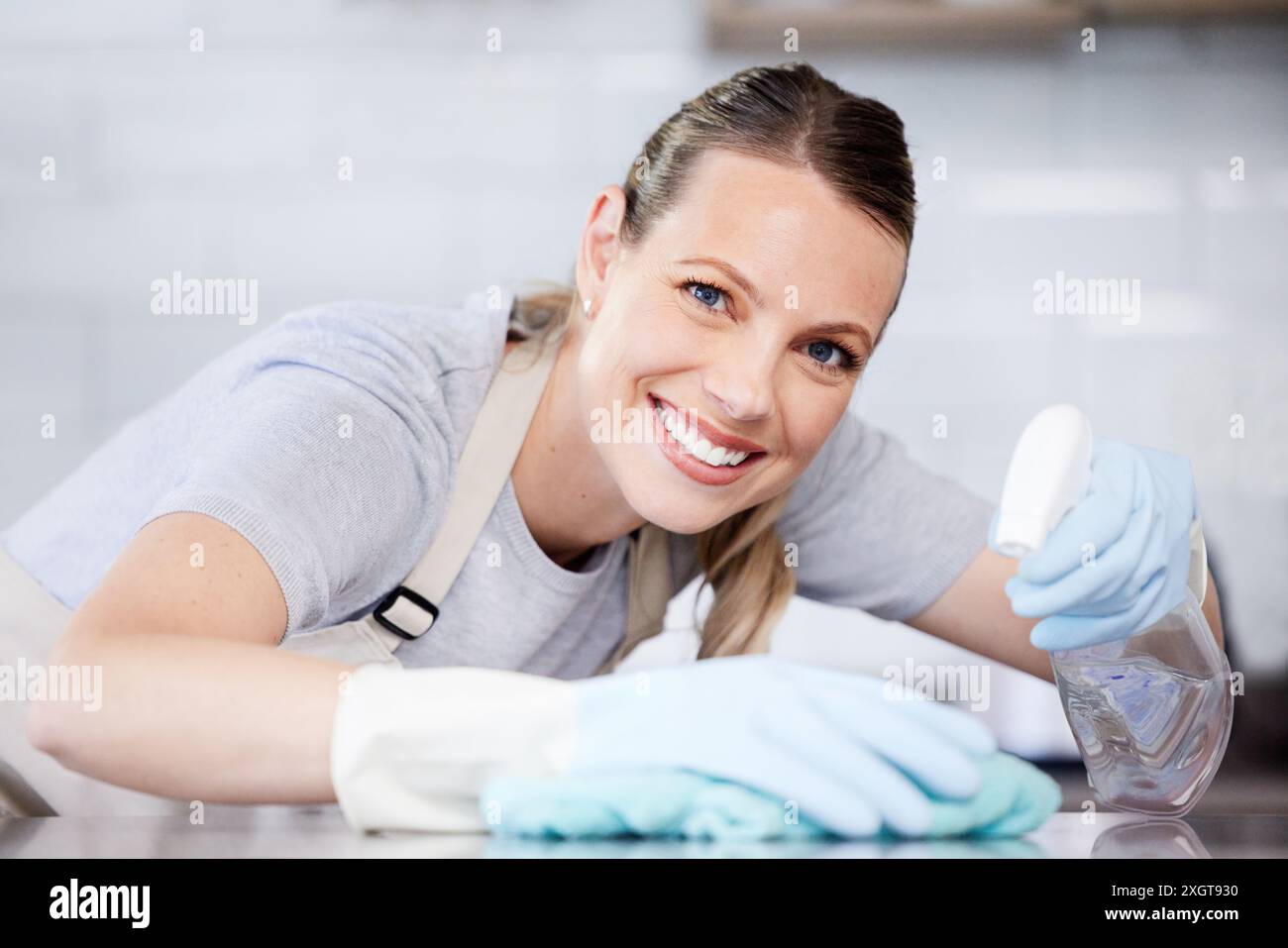 Bottle, portrait and woman wipe kitchen counter with cloth for hygiene ...