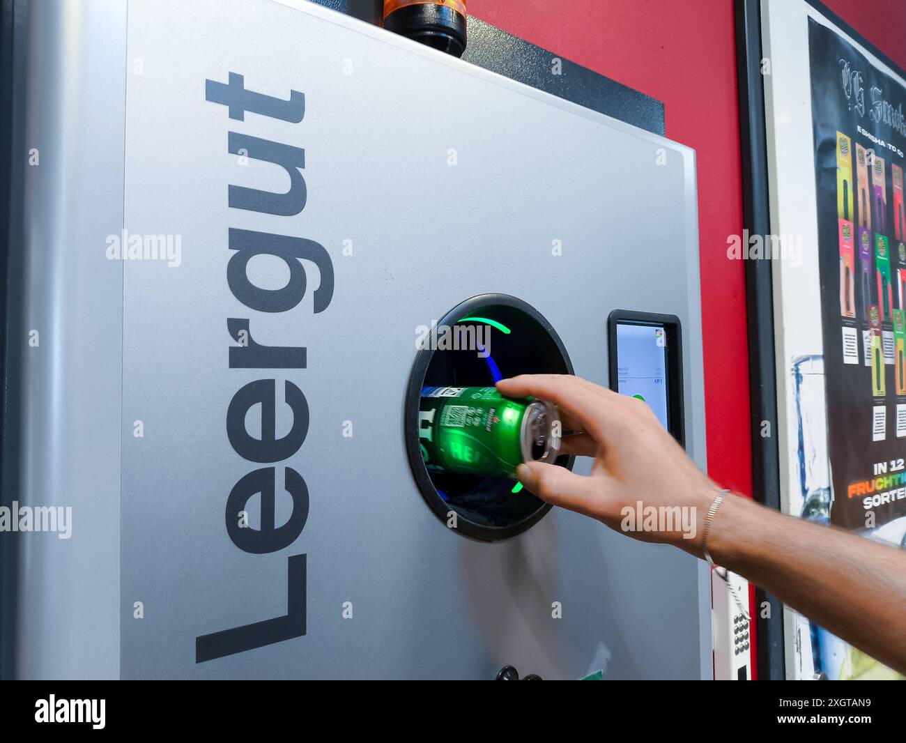 Bavaria, Germany - July 10, 2024: Customer puts an empty beer can in a ...