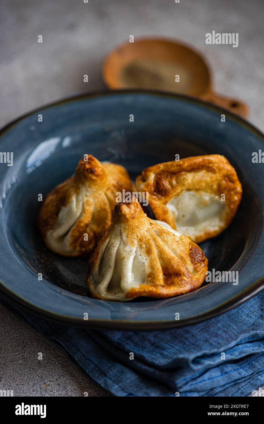 Three freshly cooked Georgian khinkali dumplings, beautifully presented ...