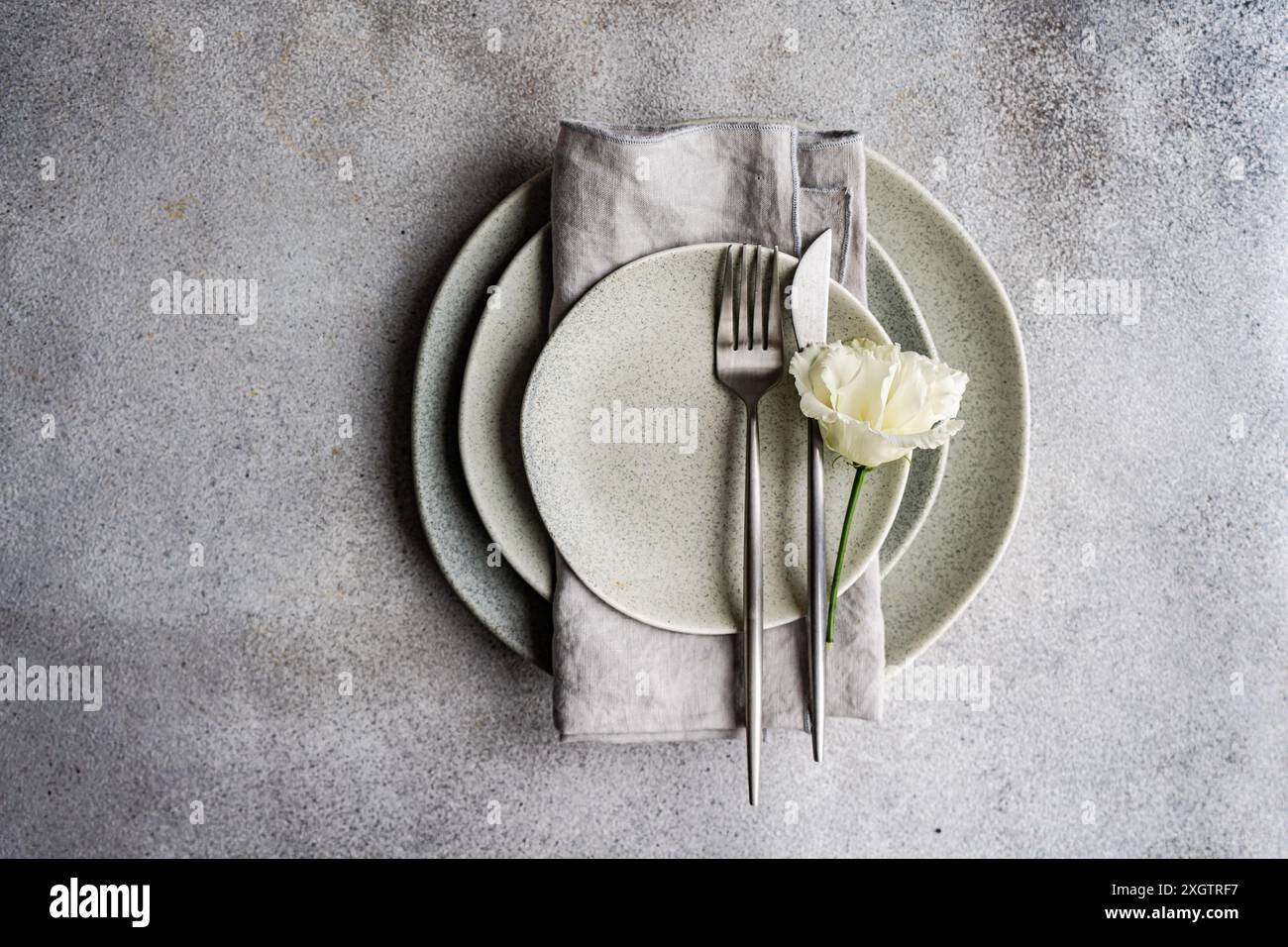 Top view of tasteful table setting featuring a stack of neutral colored ...
