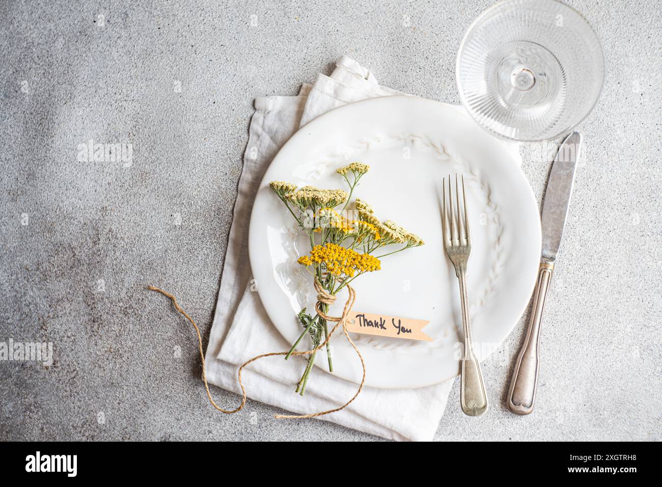 A rustic summer table setting featuring a white ceramic plate adorned ...