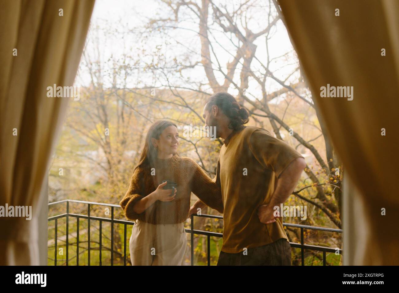 Through windows intimate moment captures a man and a woman engaging in ...
