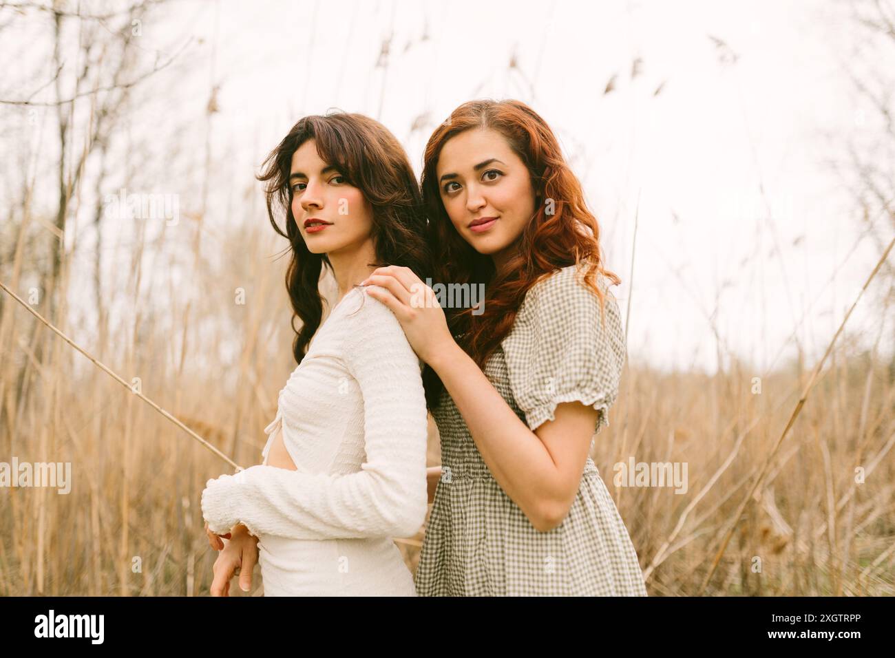 In this serene photograph, two friends stand closely, embracing in a ...