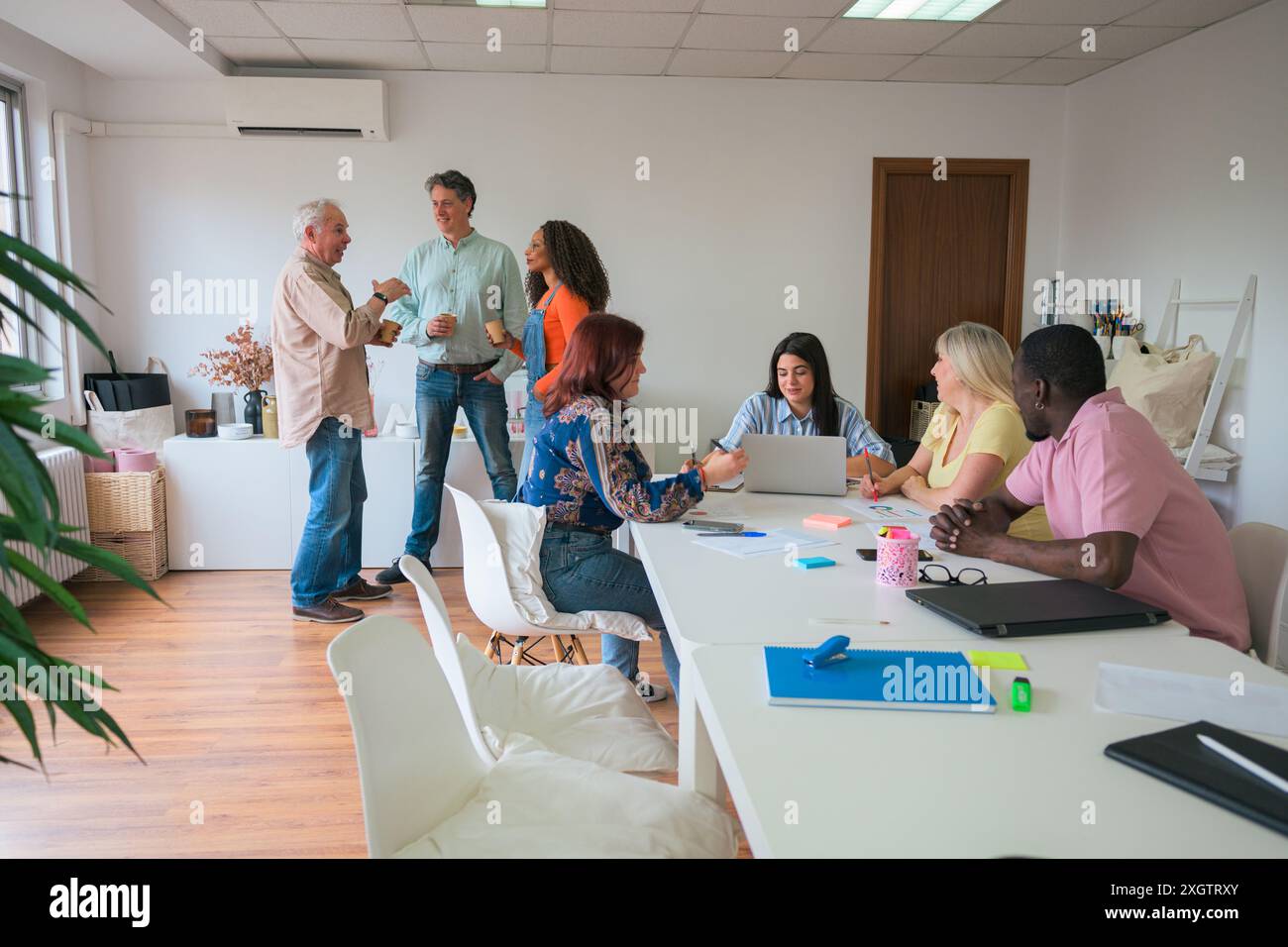 A diverse group of professionals engaging in discussion and ...