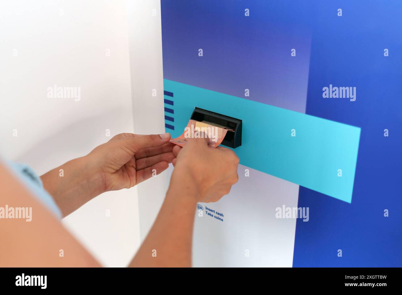 Woman hand put banknotes into coin exchange machine for changing ...