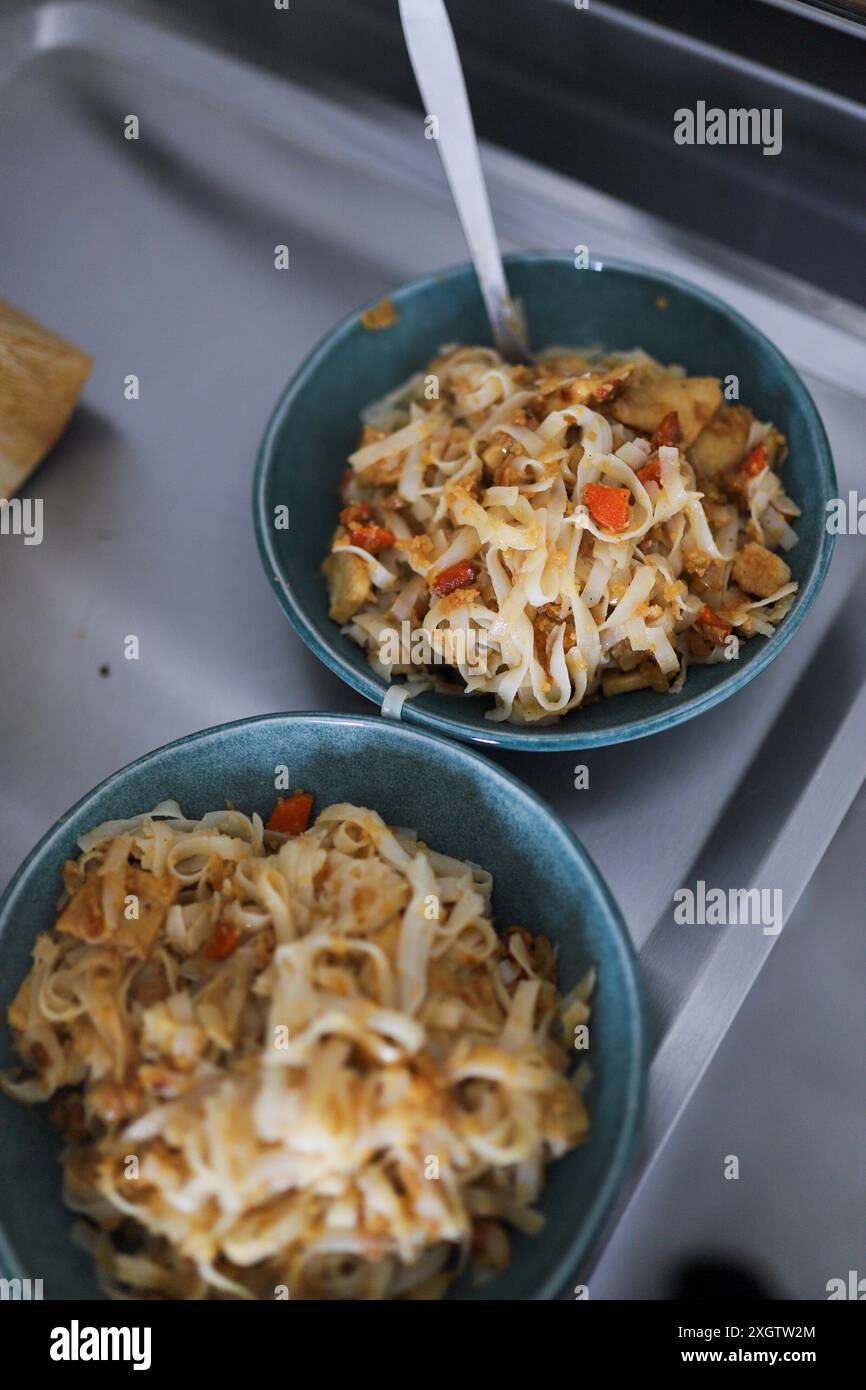 From above two teal bowls filled with homemade stir-fried noodles ...