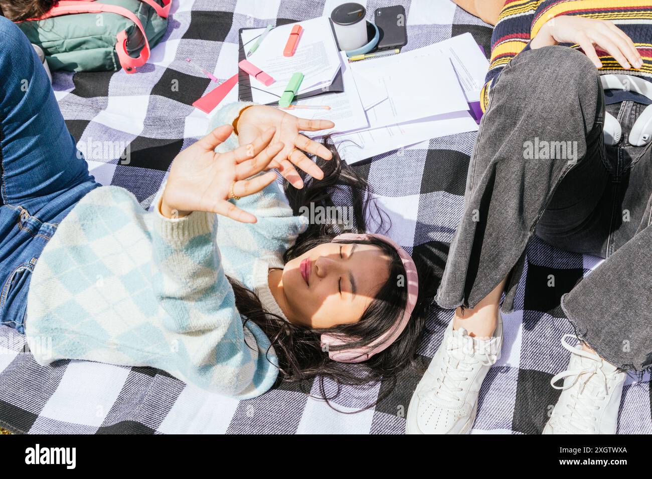 Three friends enjoying a sunny day outdoors while surrounded by study ...