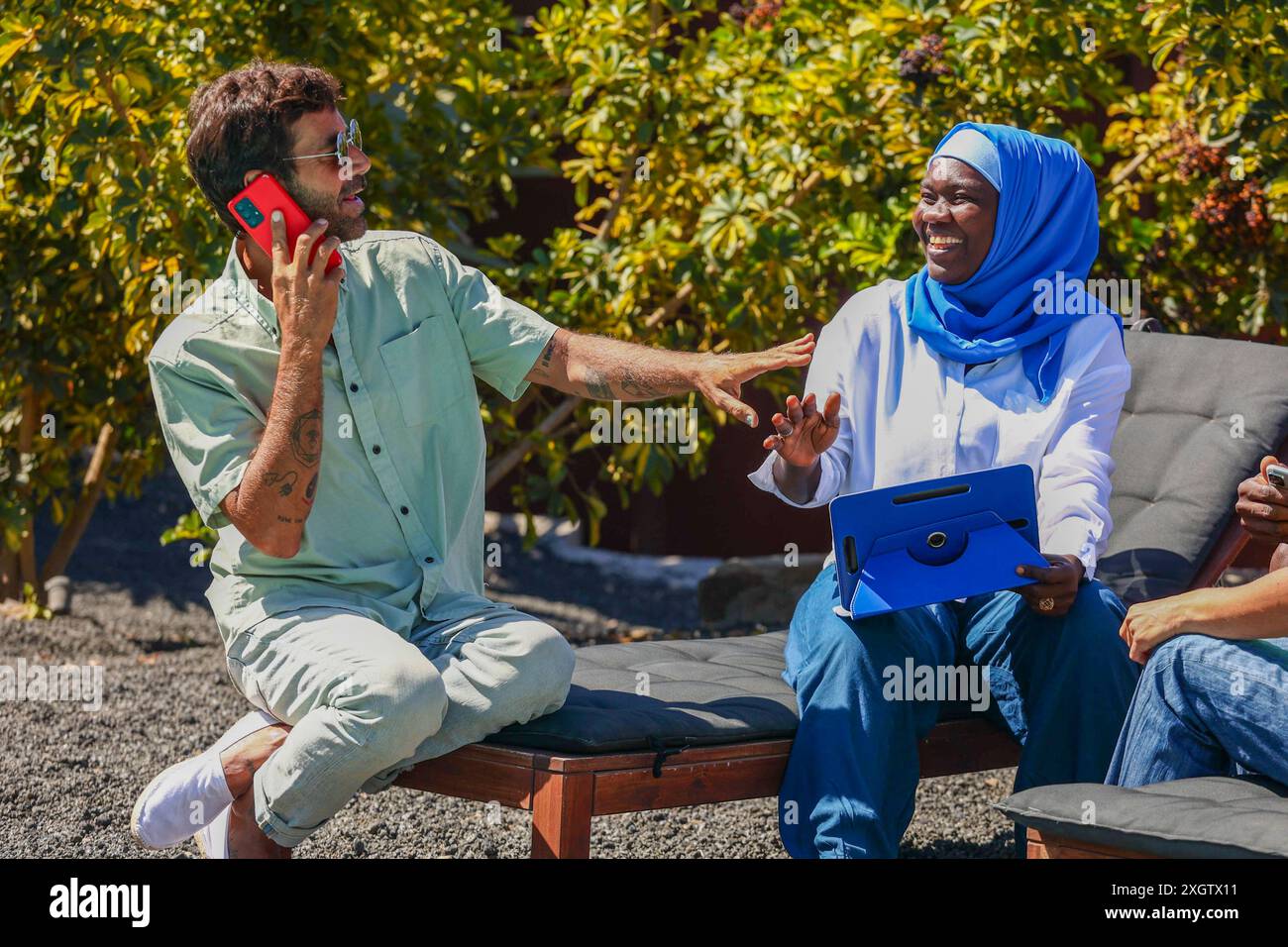 A Caucasian man and a Muslim African woman, wearing a hijab, enjoy a ...