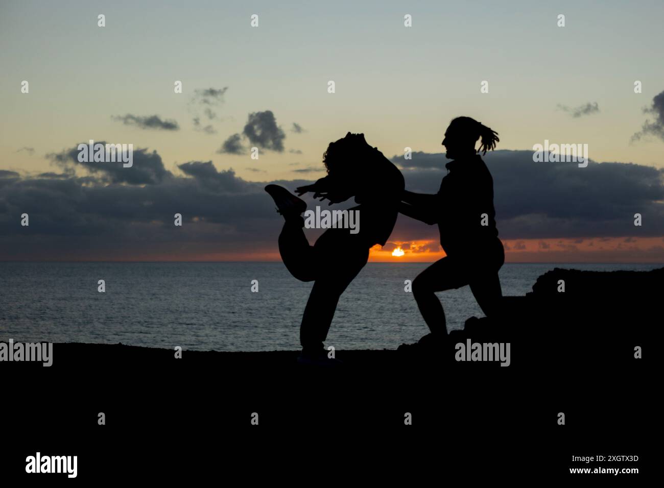 Silhouette of a Caucasian male dancer with dreadlocks and a female ...