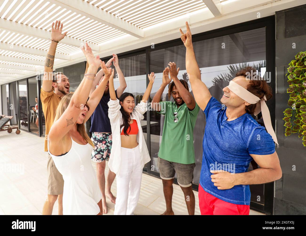 A group of multiethnic friends enjoy a playful moment in a blindfold ...