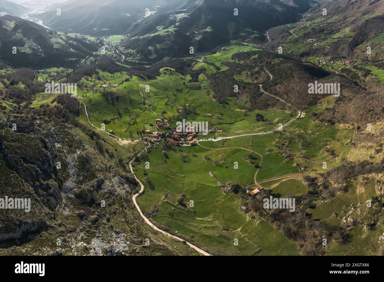 An aerial shot capturing a stunning, secluded valley village surrounded ...