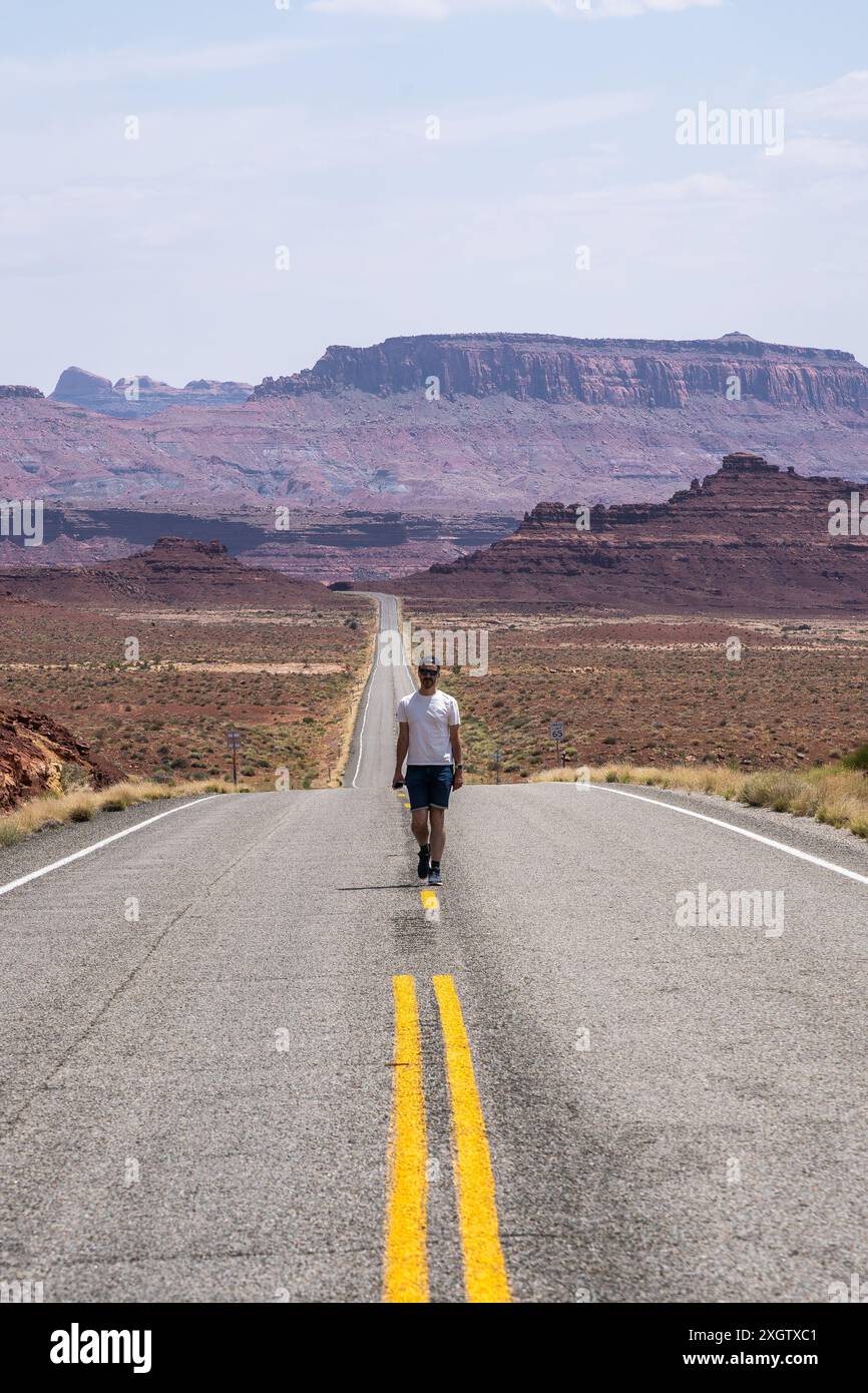 A man walks down a deserted road with the expansive landscape of White ...
