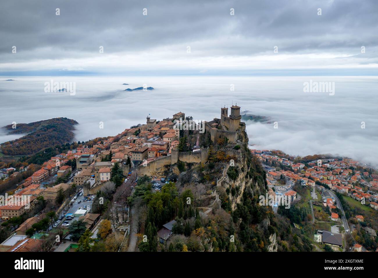 A serene aerial view of San Marino shows the cloud-covered landscape ...