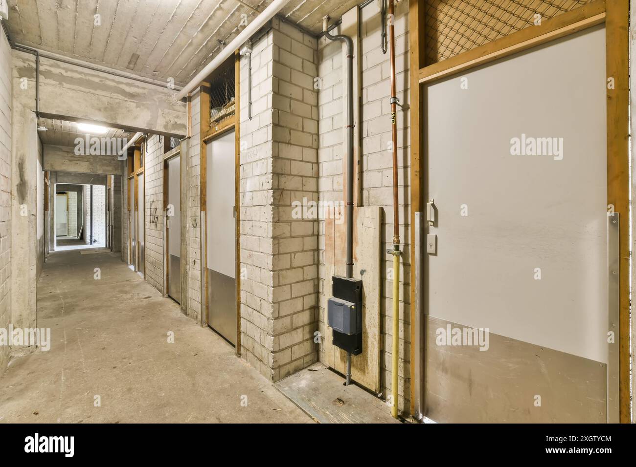 Interior view of an unfinished hallway featuring a series of doors ...