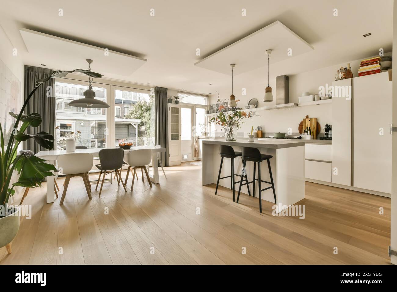 A well-lit, open floor plan featuring a modern kitchen with a white ...