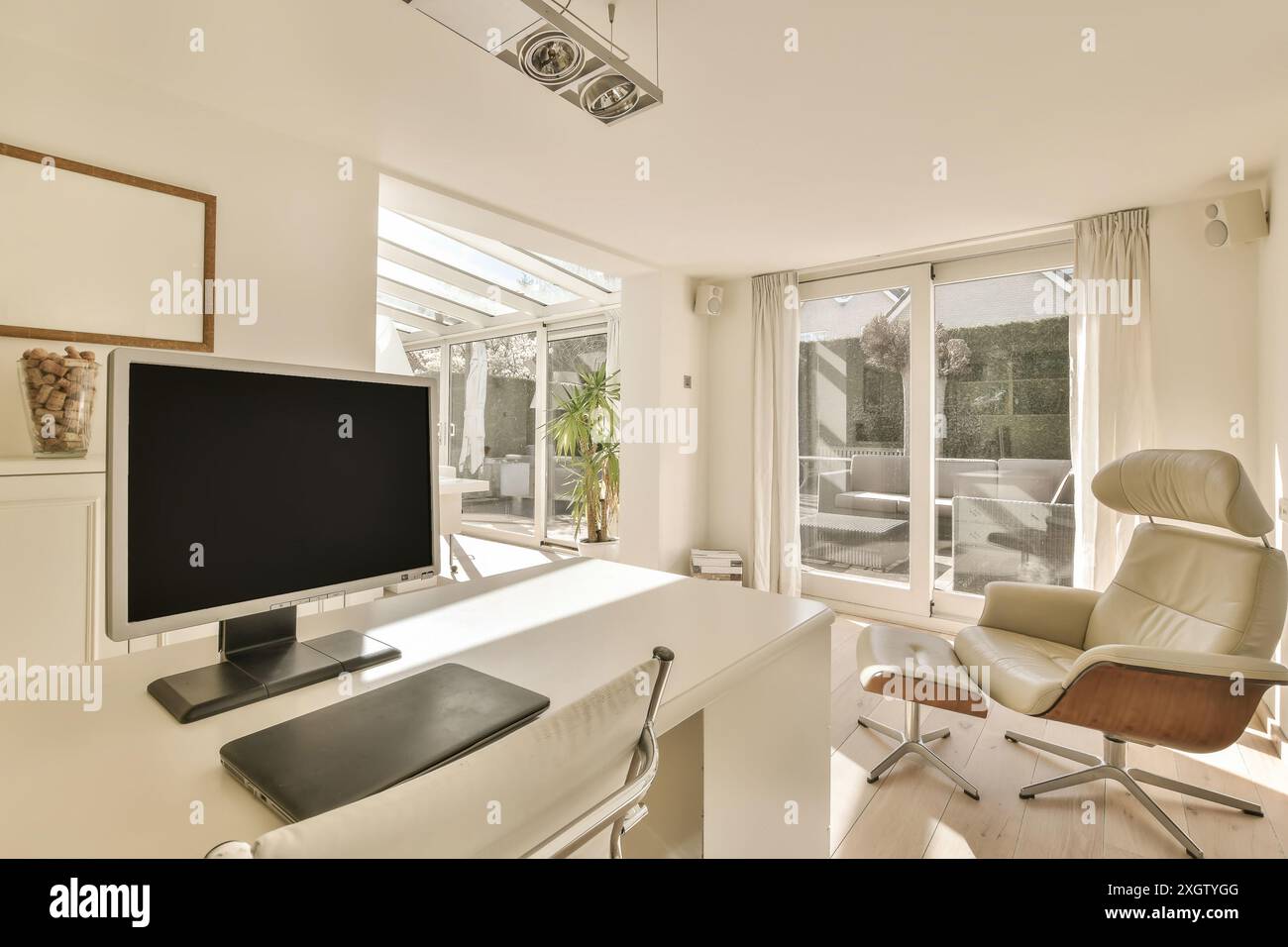 A well-lit home office featuring a modern desk setup, complete with a ...