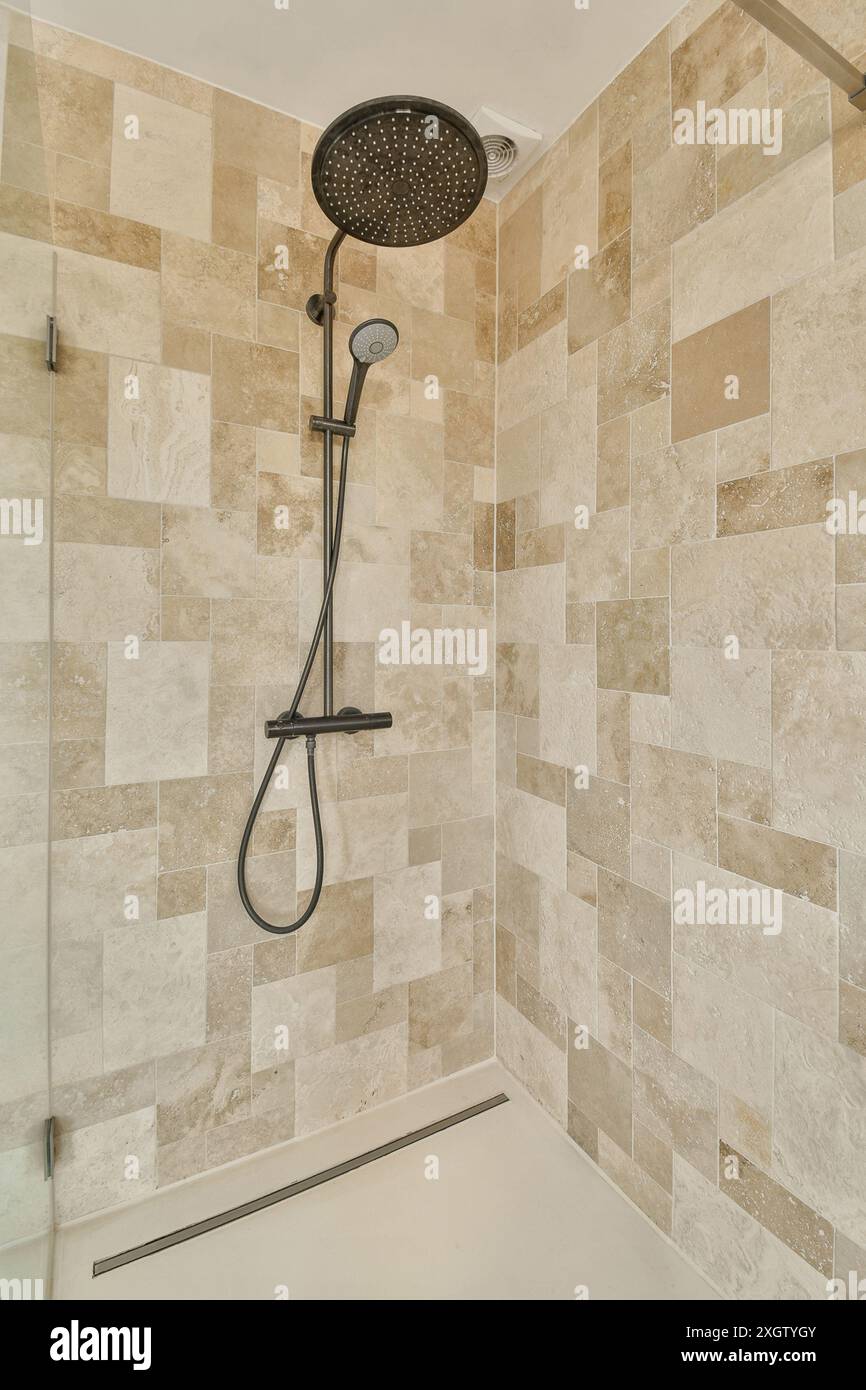 A contemporary shower setup featuring a large, round, wall-mounted ...